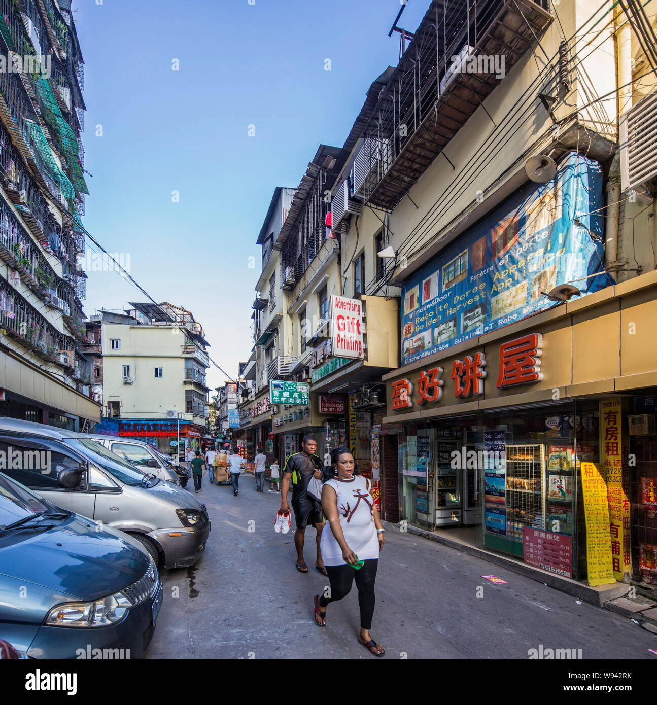 African people and local Chinese residents walk past bakeries ...