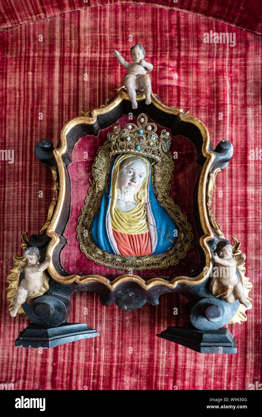 A small reliquary religious figure in a display cabinet Stock Photo - Alamy