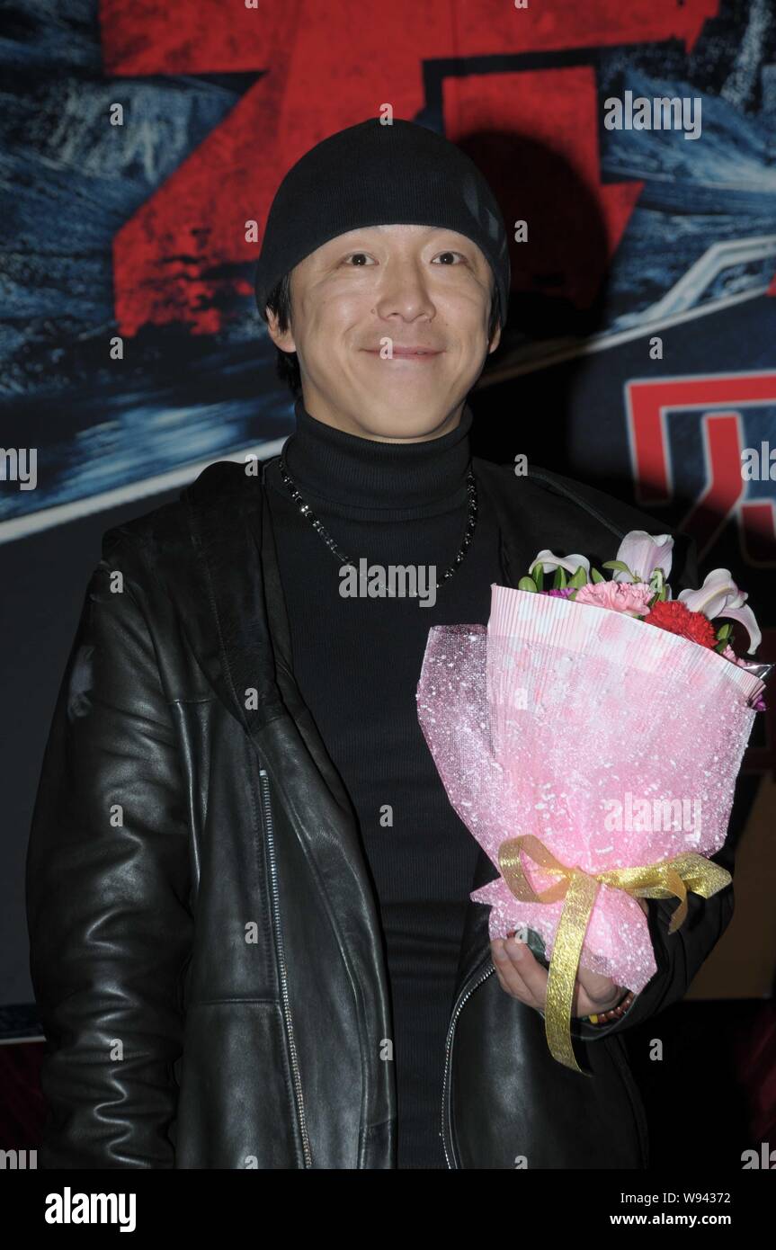 Chinese actor Huang Bo smiles holding a bouquet of flowers at a ...