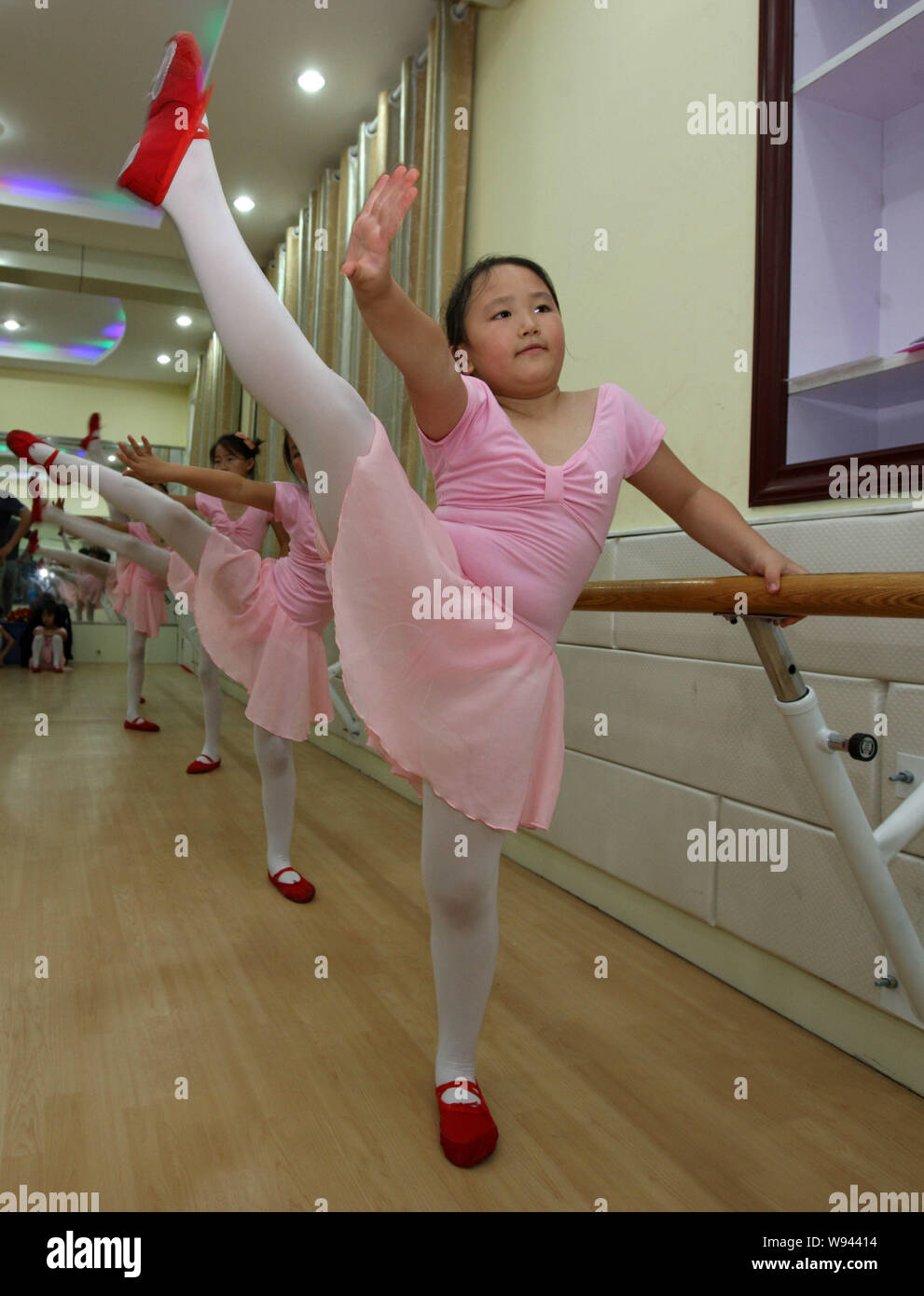 Young Chinese girls lift their right legs to learn ballet dancing ...