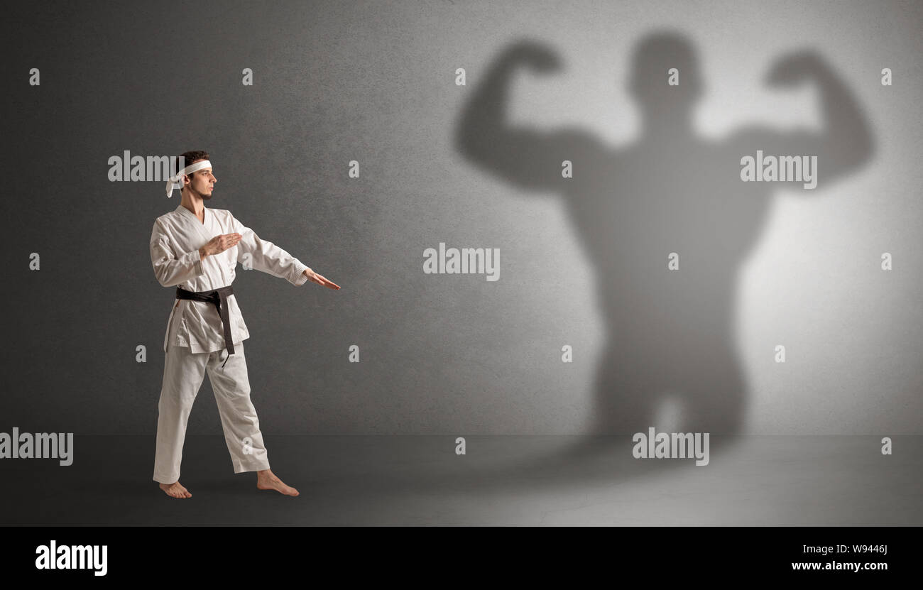 Young karate man fighting with a big black scary shadow Stock Photo - Alamy