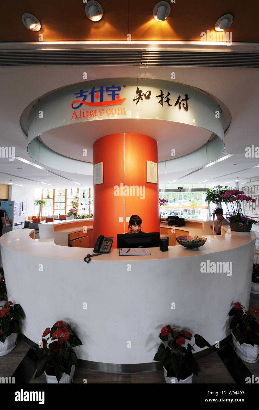 --FILE--A Chinese employee works at the front desk in the headquarters ...
