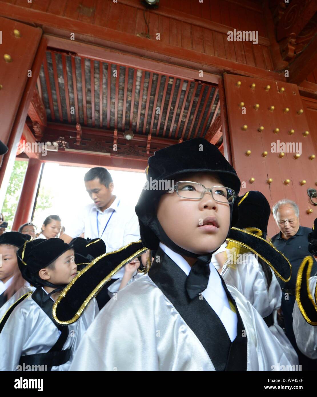 First-grade pupils wearing traditional Chinese uniforms attend the ...