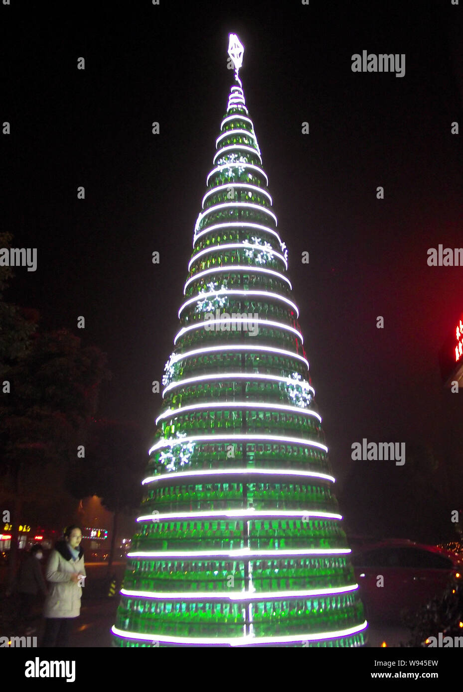 A pedestrian looks at a 10-meter-tall Christmas tree made up of more ...