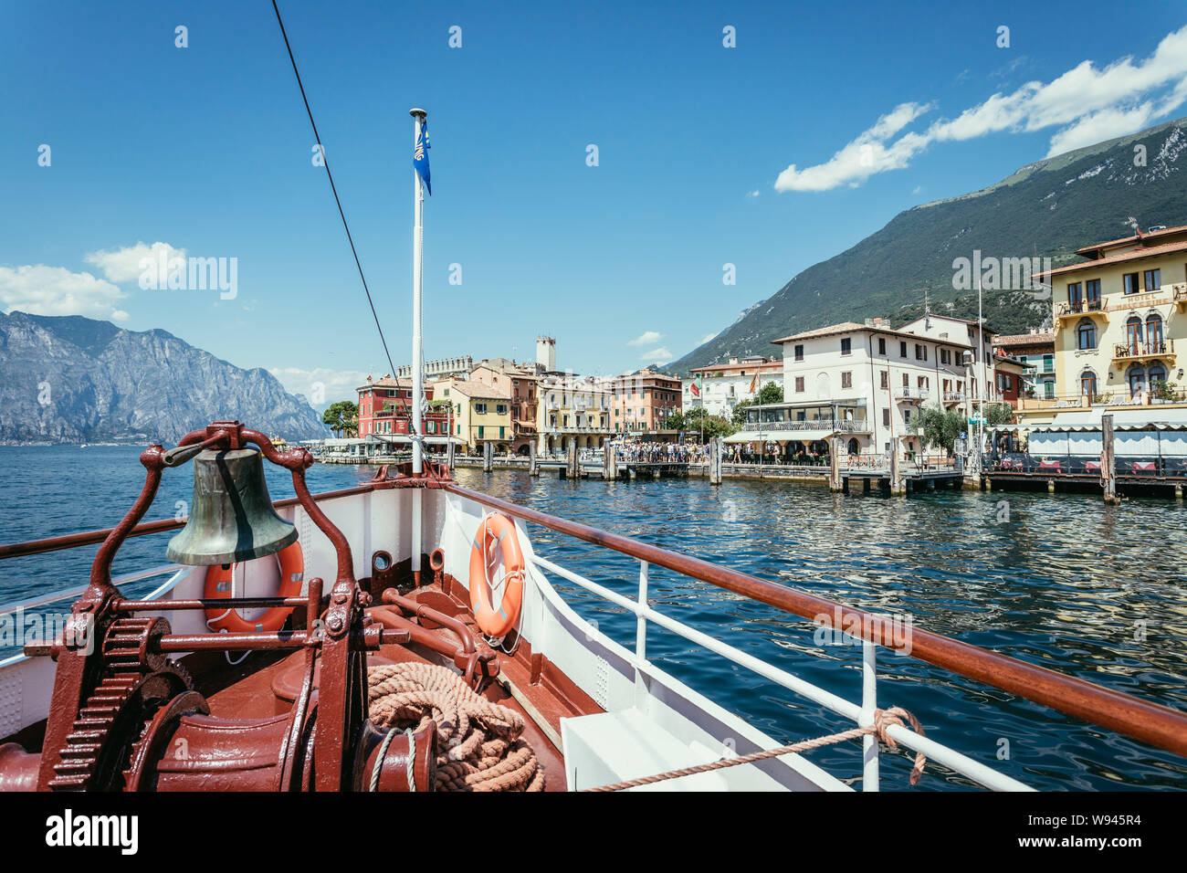 Bow of a boat with boat bell on a cruise tour. Blue water, mountain ...