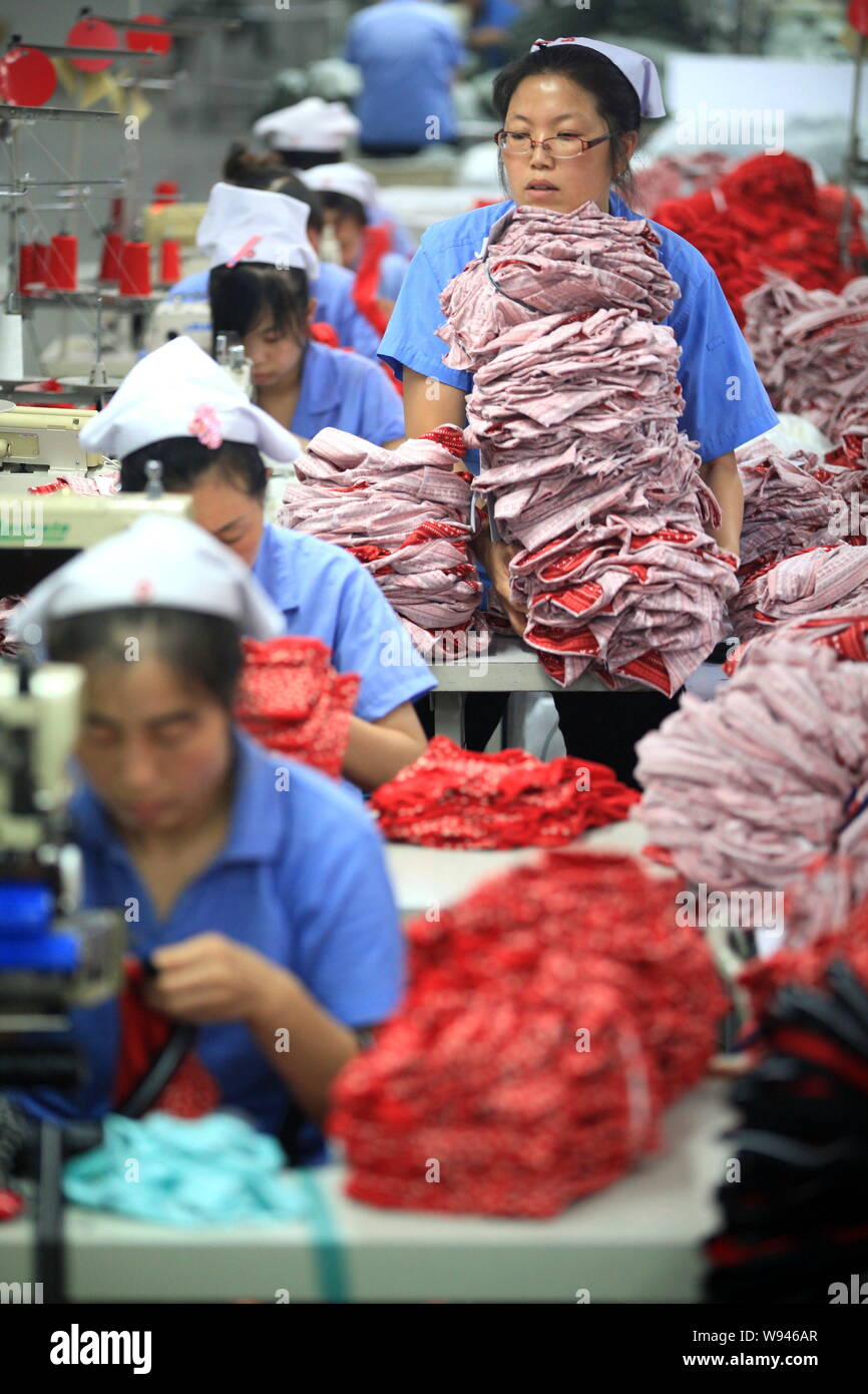 Female Chinese workers sew clothes to be exported at a garment factory of Jifa Group in Jimo ...