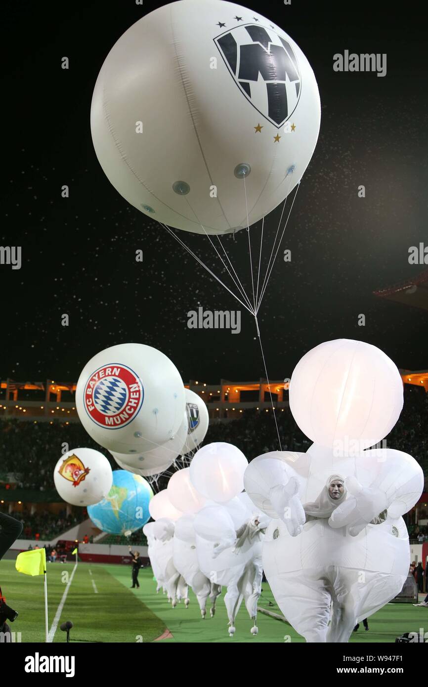 Entertainers hold balloons with the logos of football clubs at the ...