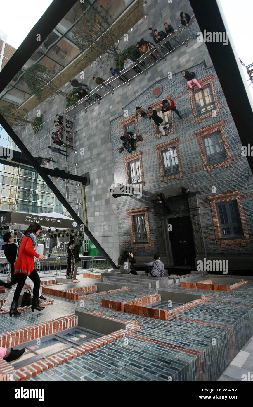 Visitors pose on a model of Shikumen building on the ground, looking at ...