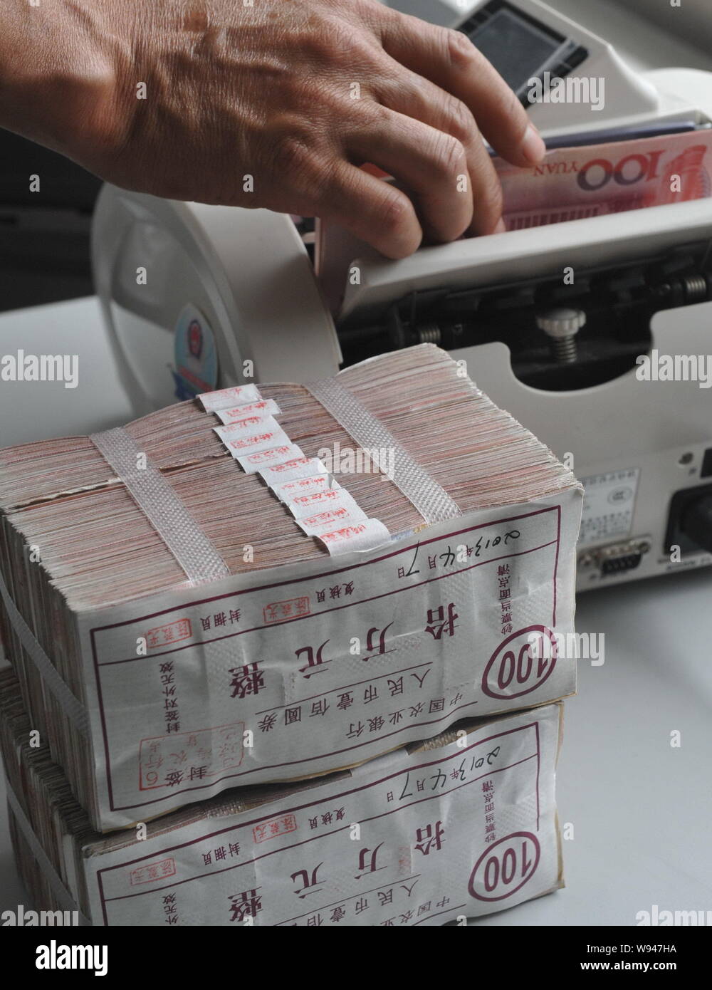 --FILE--Chinese clerks count RMB (renminbi) yuan banknotes at a branch ...