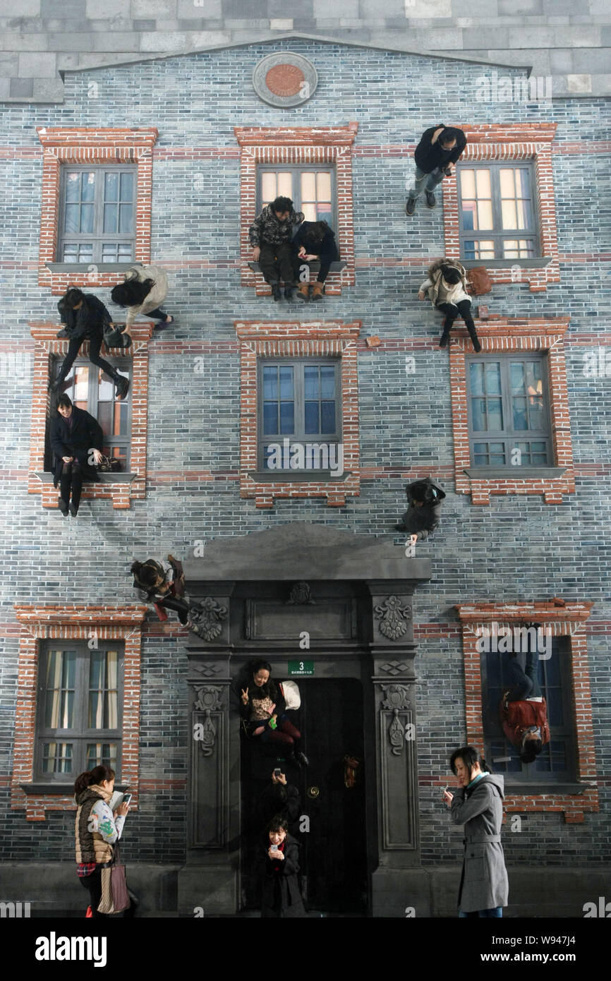 Visitors pose on a model of Shikumen building, which is reflected by a ...