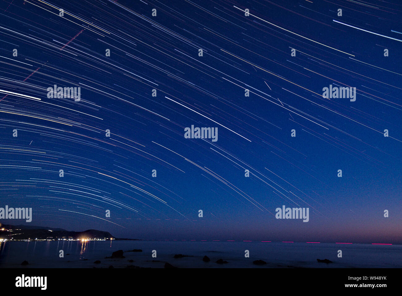 Star trail in a summer starry night over the sea, where the stars seem ...