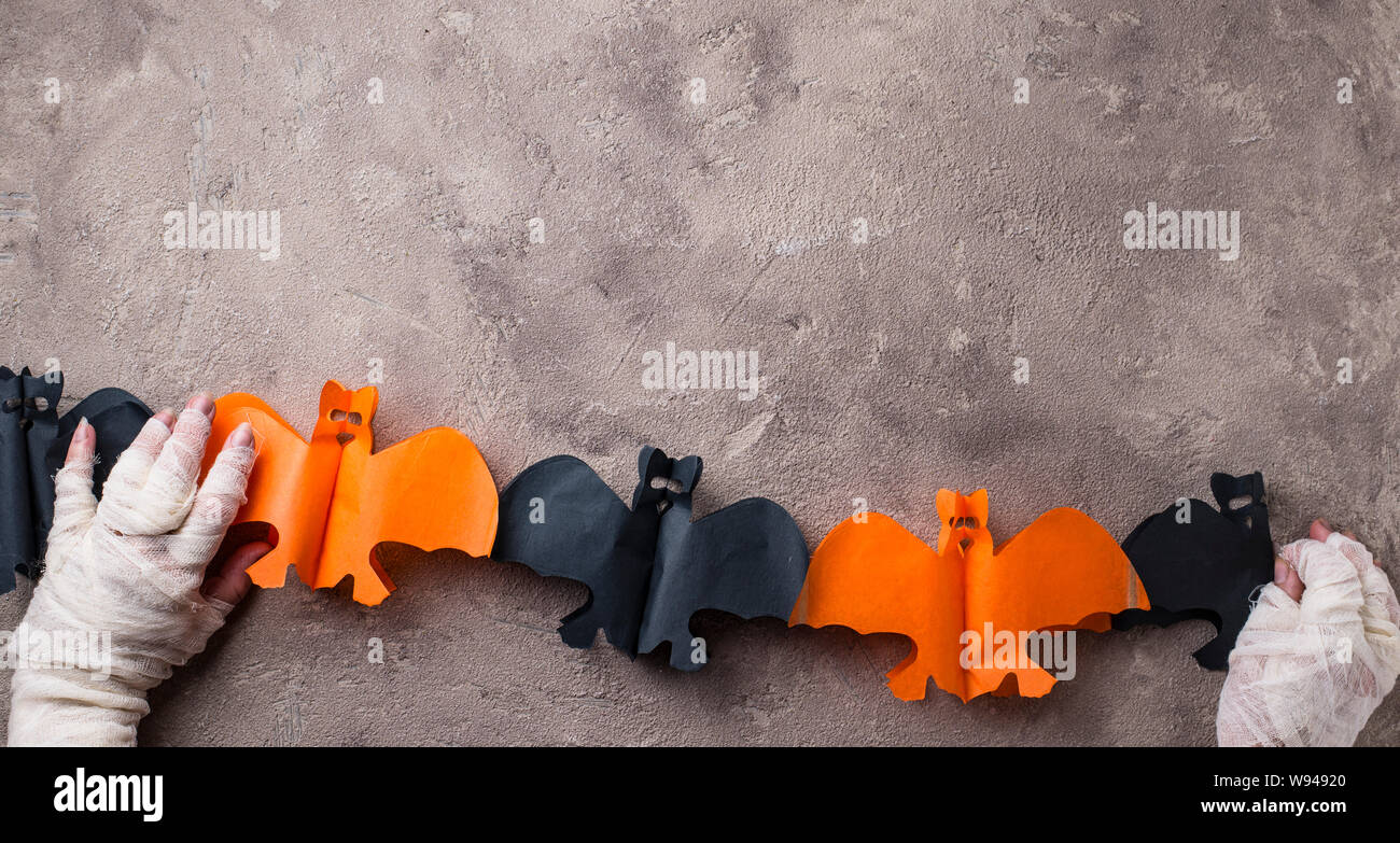 Halloween background with mummy hand and garlands in shape of bats ...