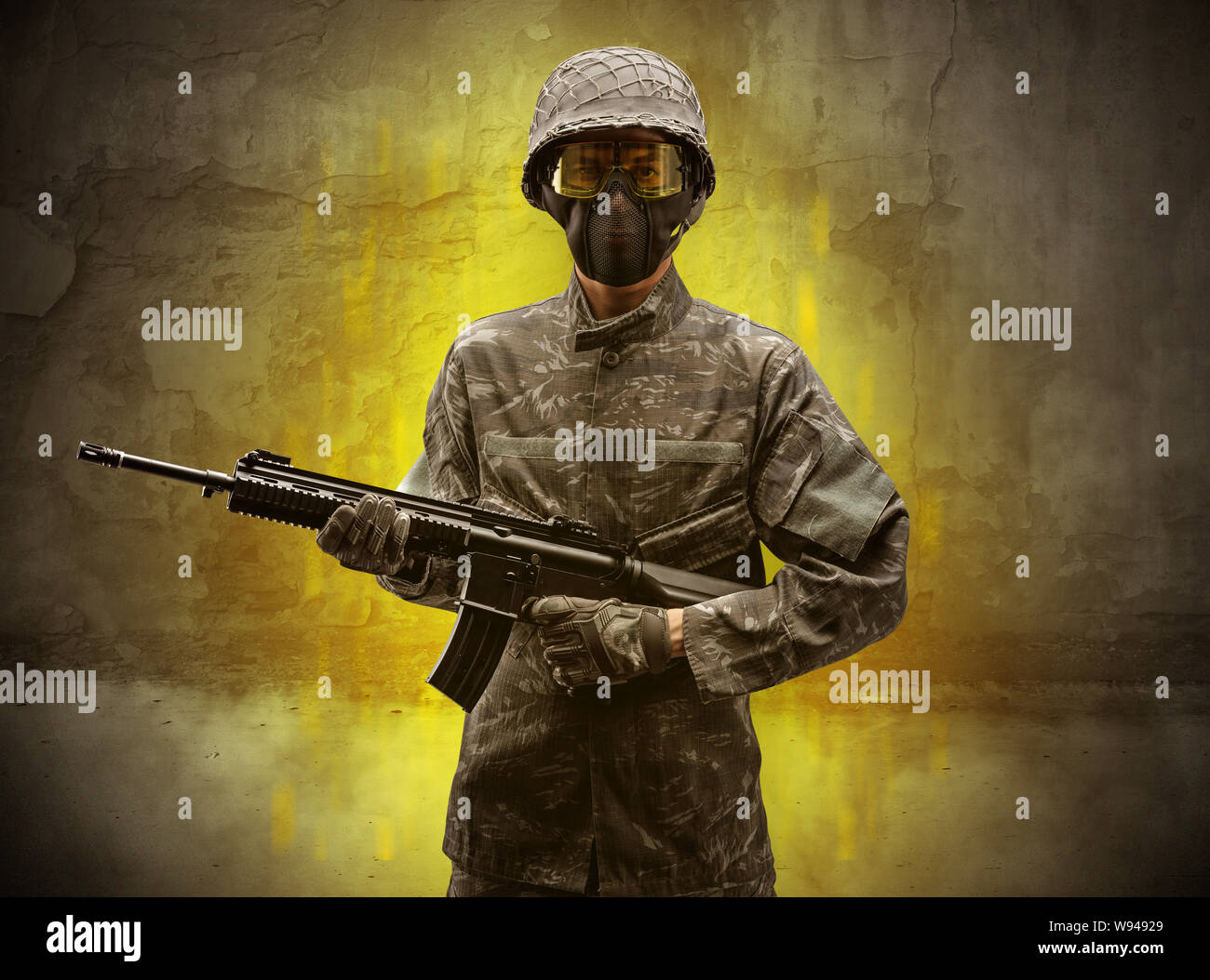 Hazard, menace soldier in a ruined crumbly building with arms on his ...