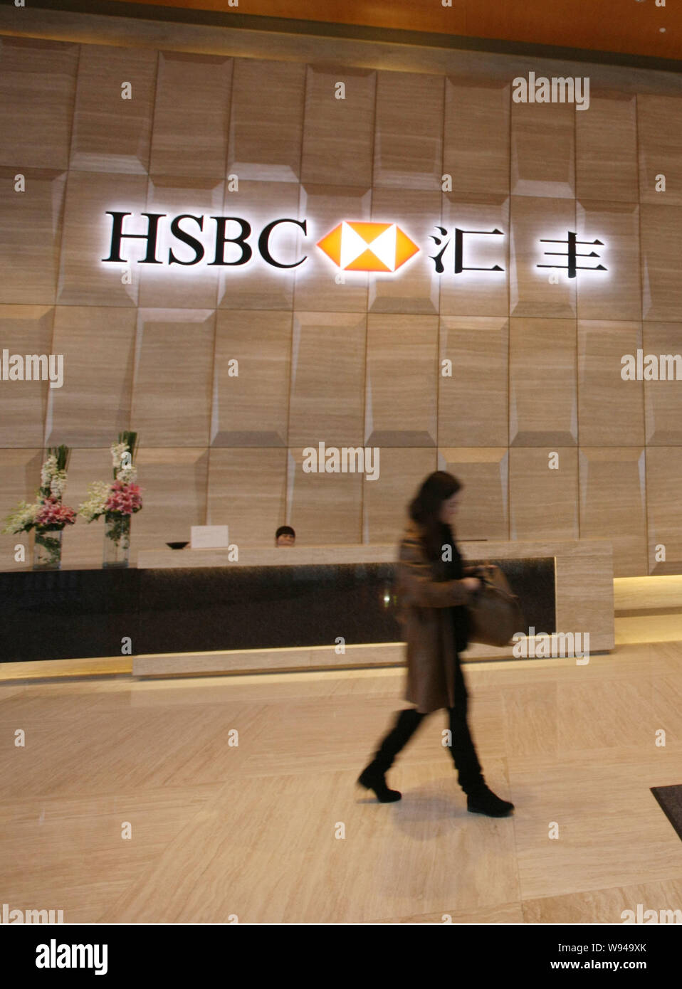 A woman walks past the front desk at the China headquarters of HSBC in ...