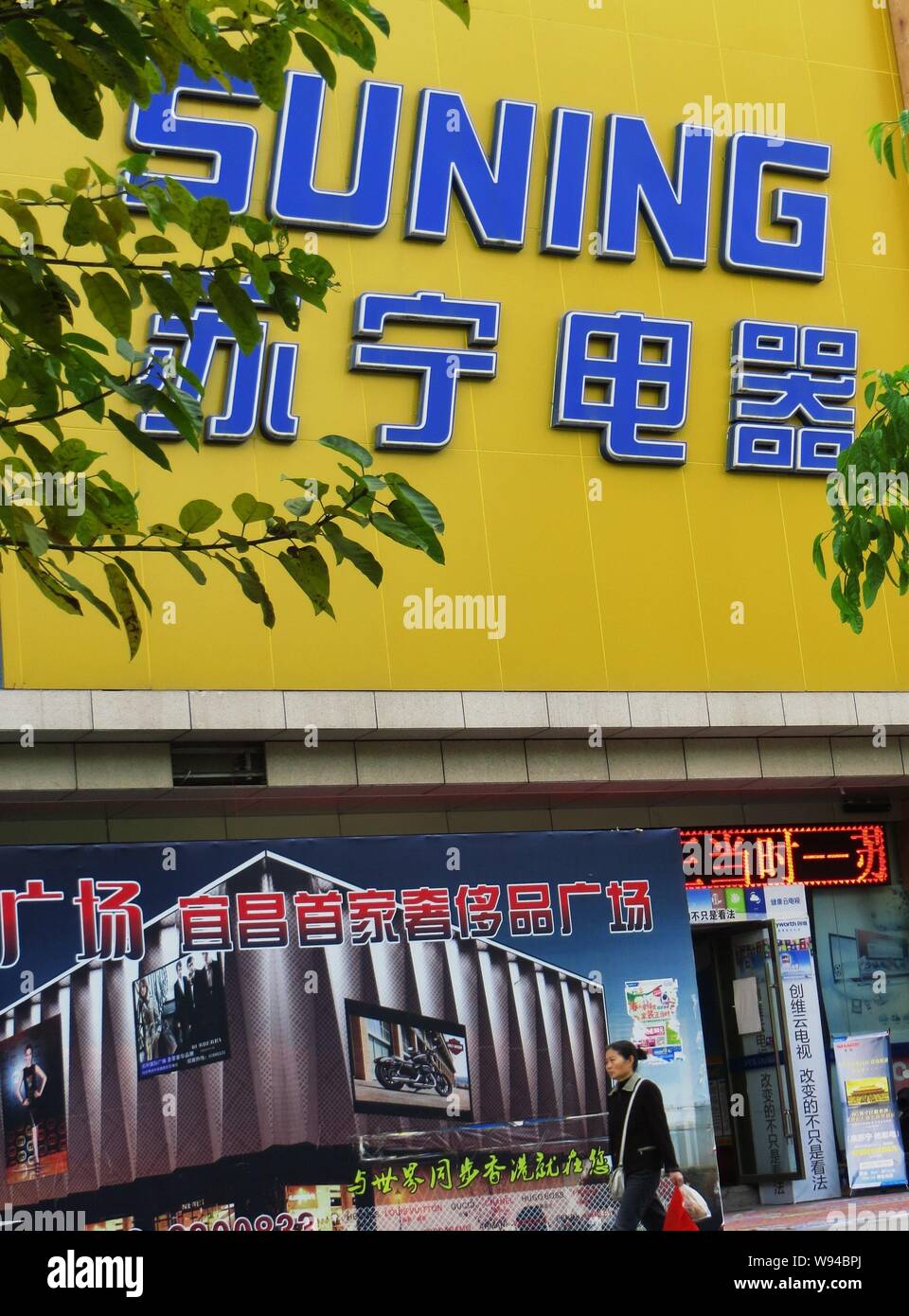 --FILE--A pedestrian walks past an advertisement of Suning appliances ...