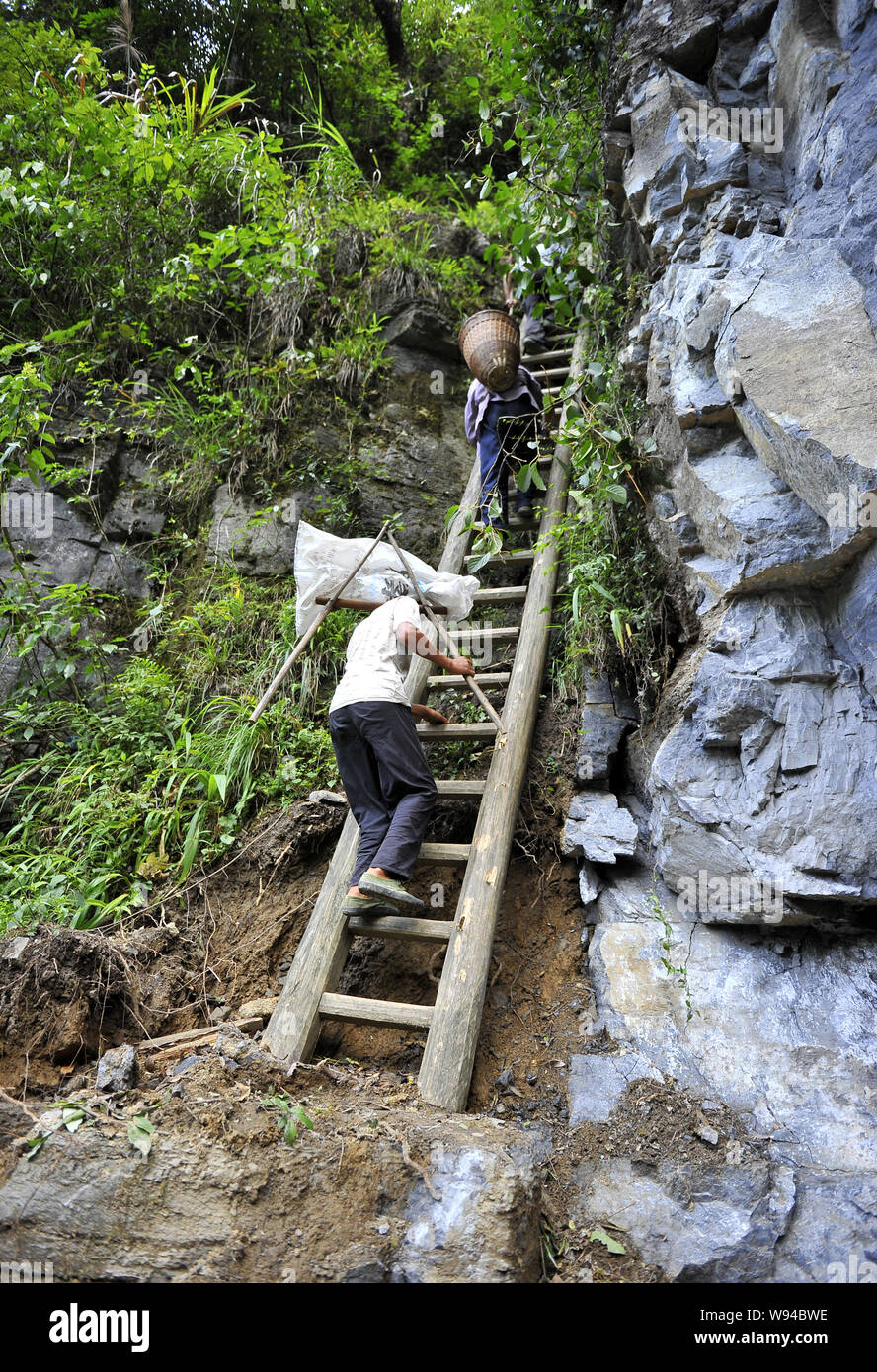 Local Chinese villagers climb the sky ladder on the cliff of a mountain ...