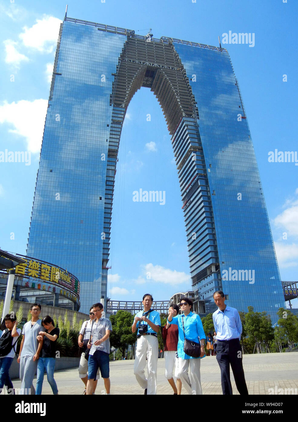 Tourists walk past the pants-shaped skyscraper, Gate of the Orient ...