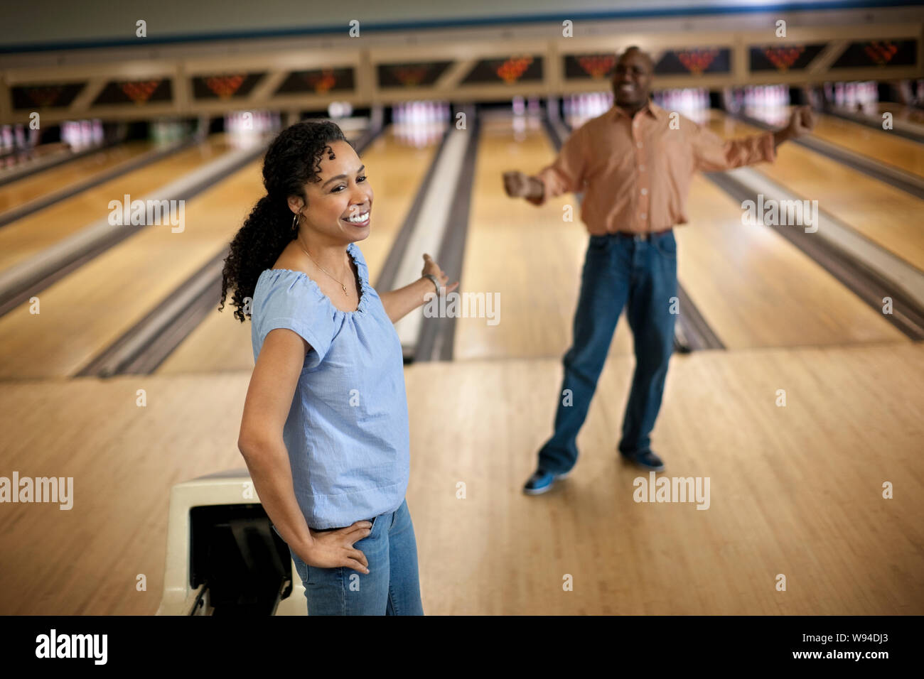 Smiling mid adult couple having fun at bowling alley Stock Photo - Alamy