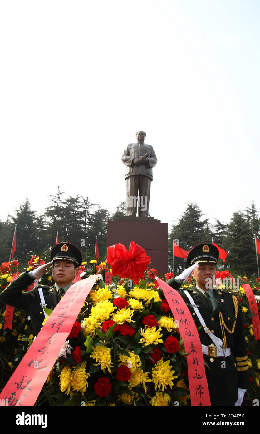 Chinese soldiers salute in front of a statue of Mao Zedong during a ...
