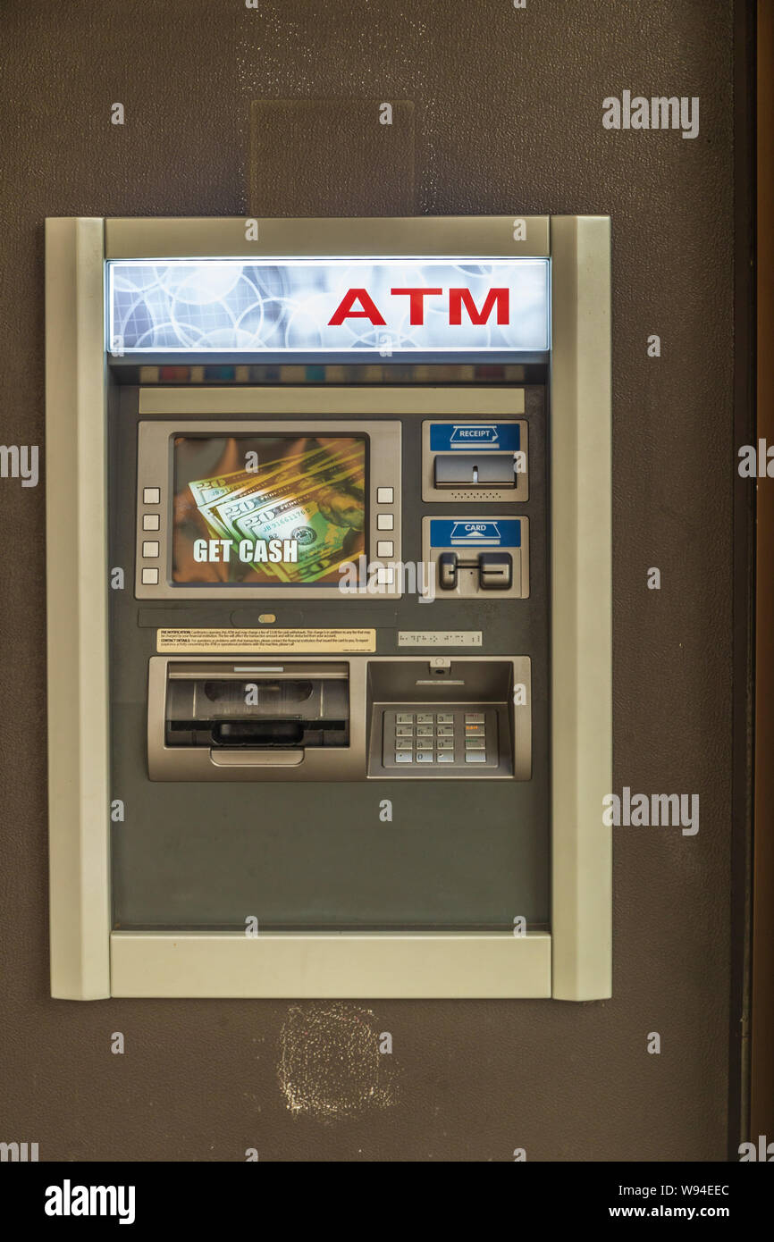 Generic ATM machine a brown wall Stock Photo - Alamy