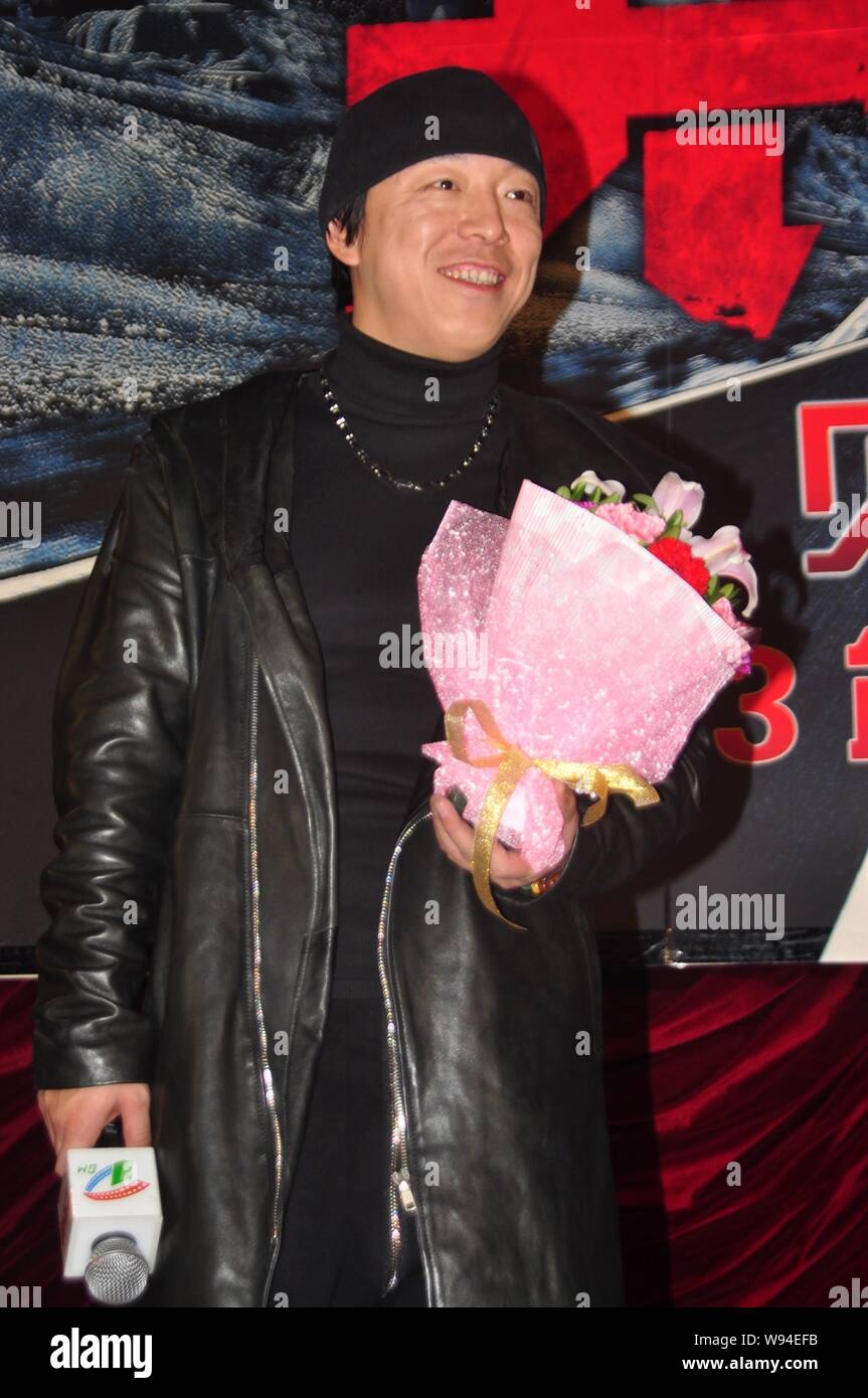 Chinese actor Huang Bo smiles holding a bouquet of flowers at a ...
