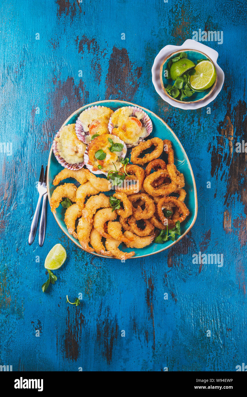 SEAFOOD hot platter baked scallops, fried squid rings and shimps Stock ...
