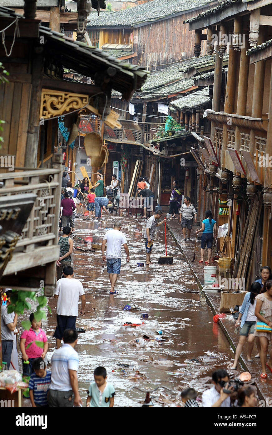 Local Chinese residents clear a flooded street in Zhongli town, YaAn ...