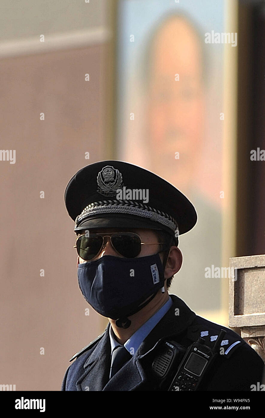 A police officer wearing a face mask stands guard in front of the ...