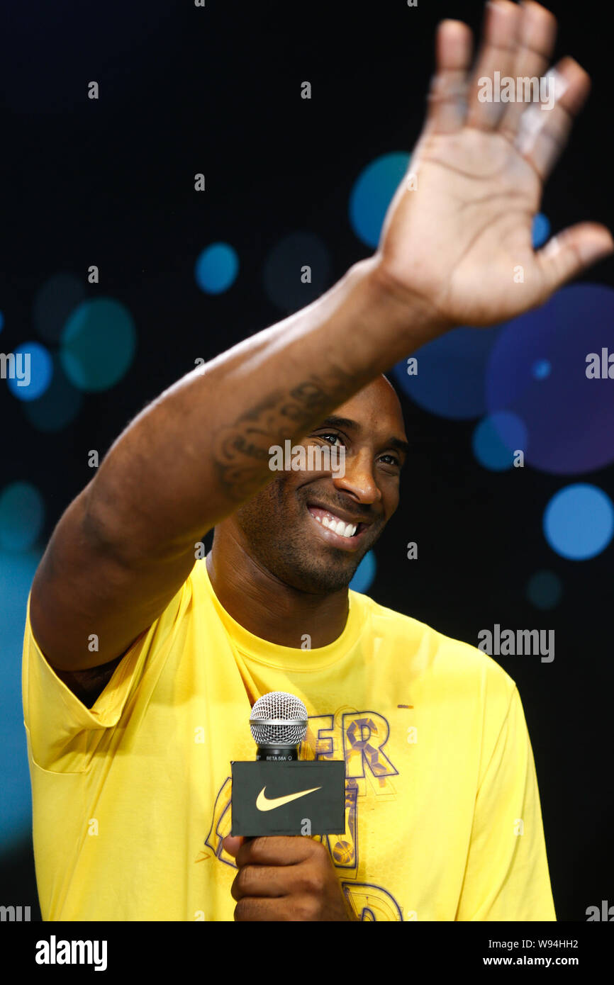 NBA star Kobe Bryant waves to fans during an interview at a basketball ...