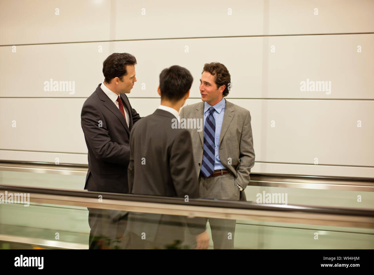 Three men stand talking hi-res stock photography and images - Alamy