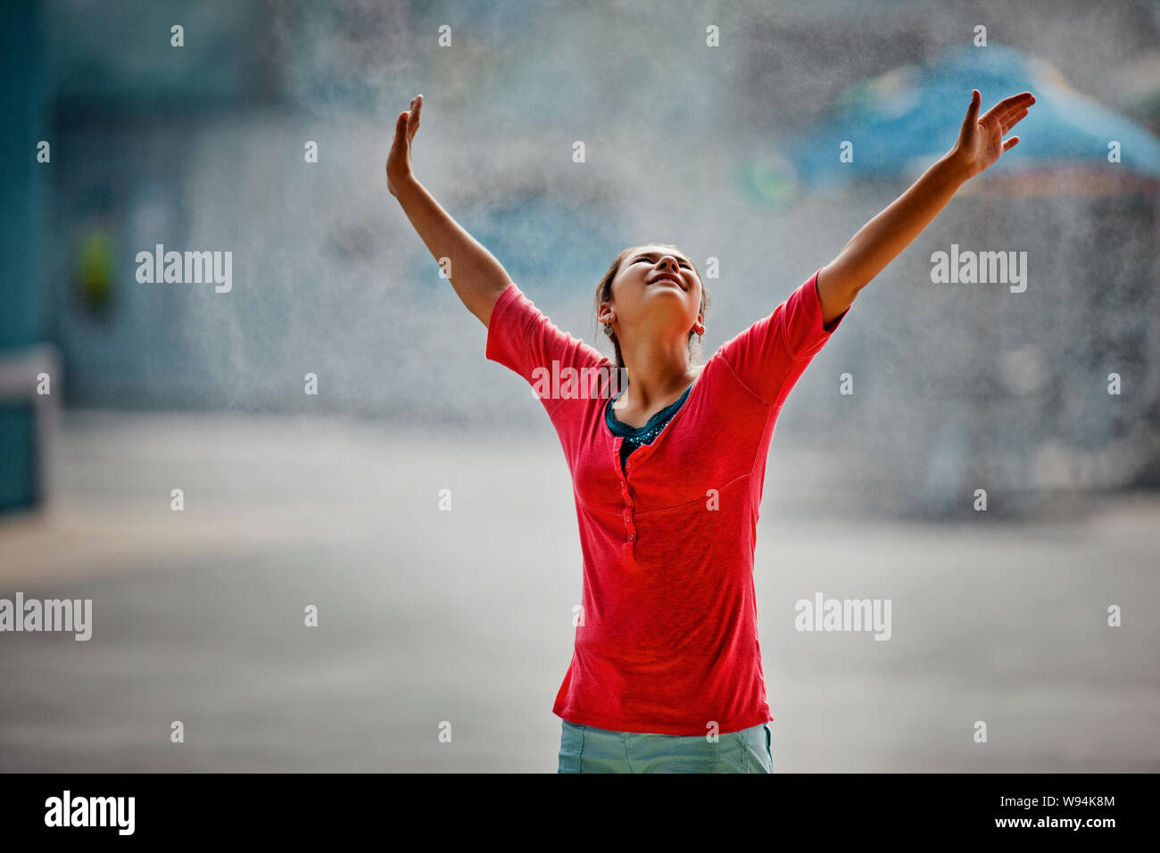 Smiling teenage girl waving her arms in the air Stock Photo - Alamy
