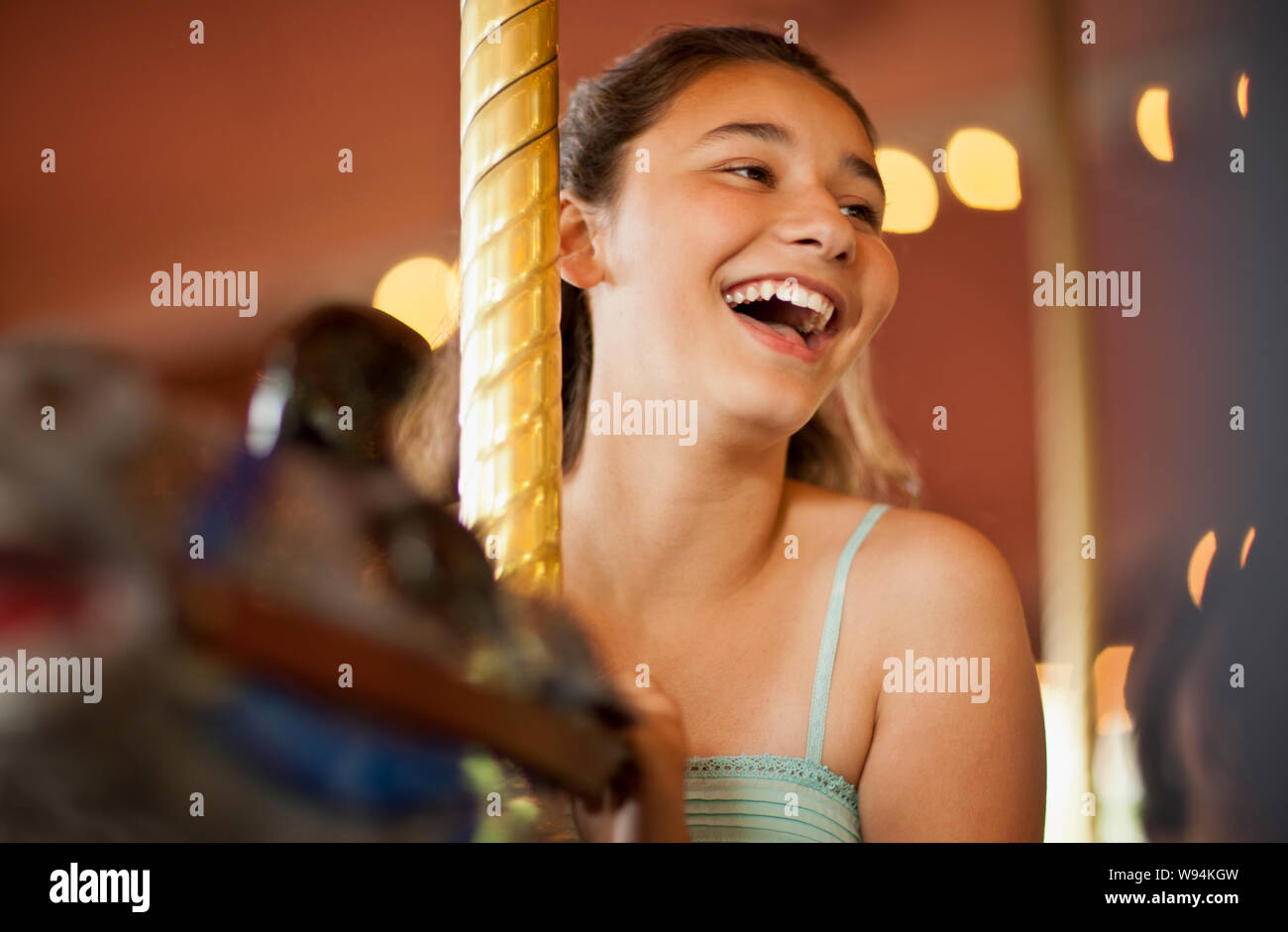 Smiling teenage girl riding a carousel at an amusement park Stock Photo ...