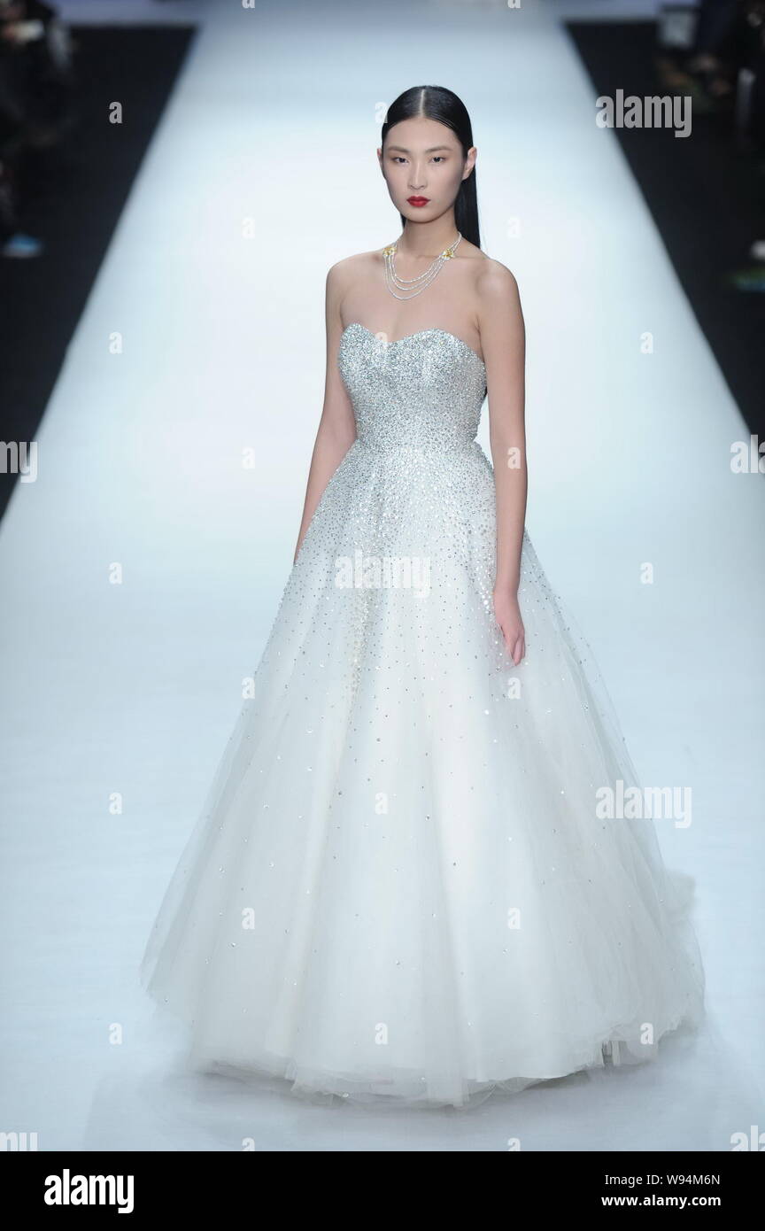 A model displays a new creation by designer Peng Jing at the All White ...