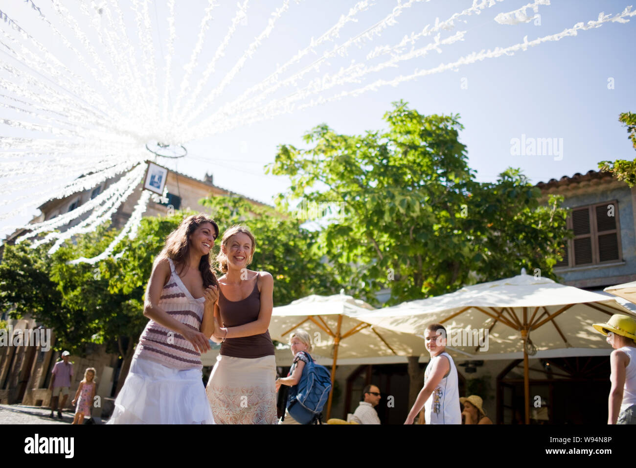 Young adult woman walking down a street filled with streamers Stock ...