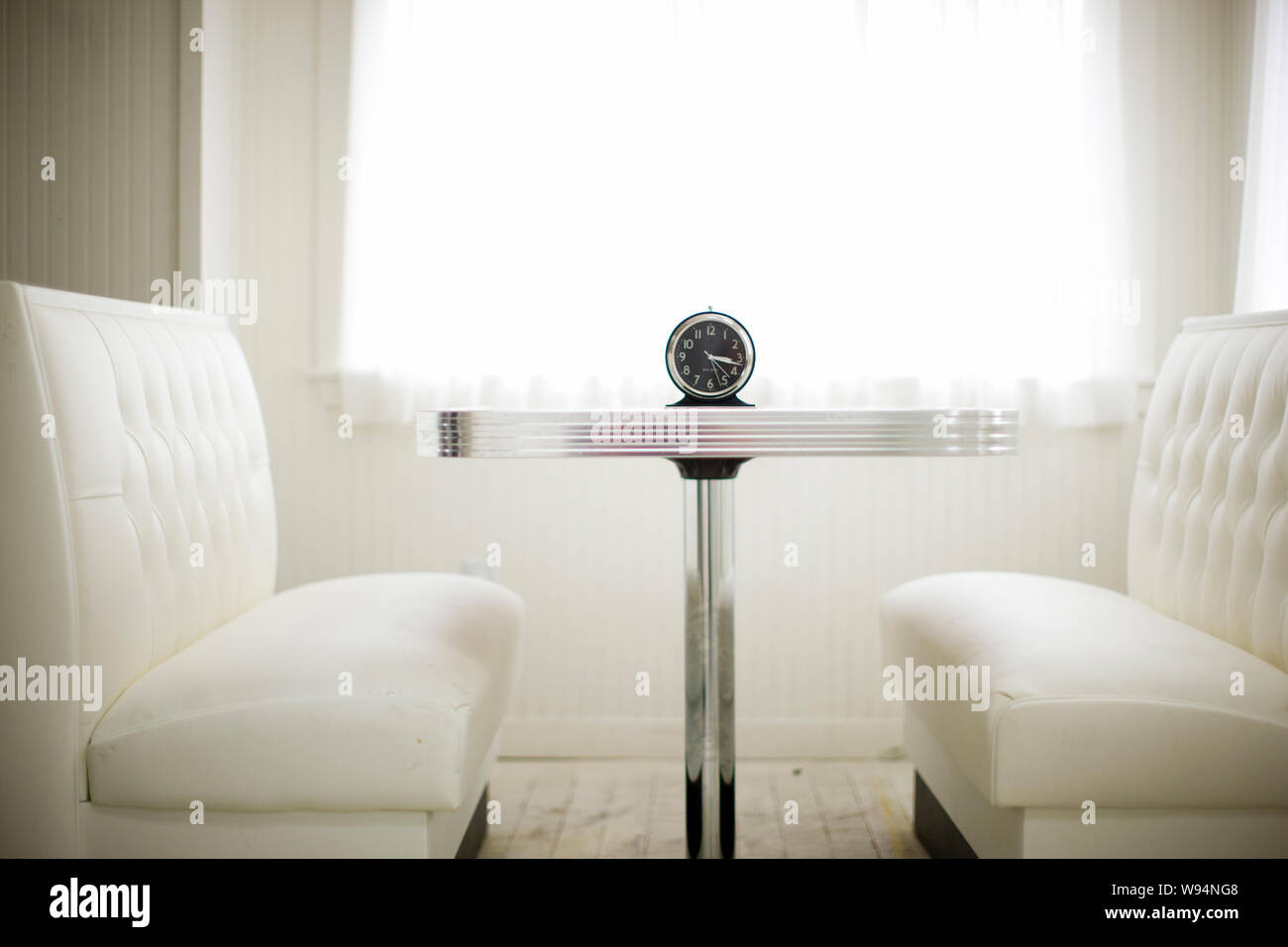 Dining room table with an alarm clock sitting on it Stock Photo - Alamy