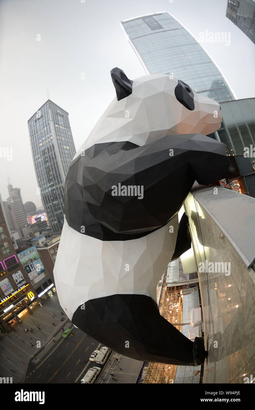 A giant panda-shaped art installation is being installed on the facade ...