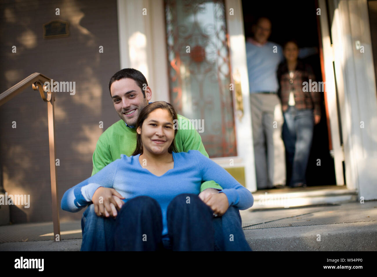 Couple sitting on front doorstep Stock Photo - Alamy