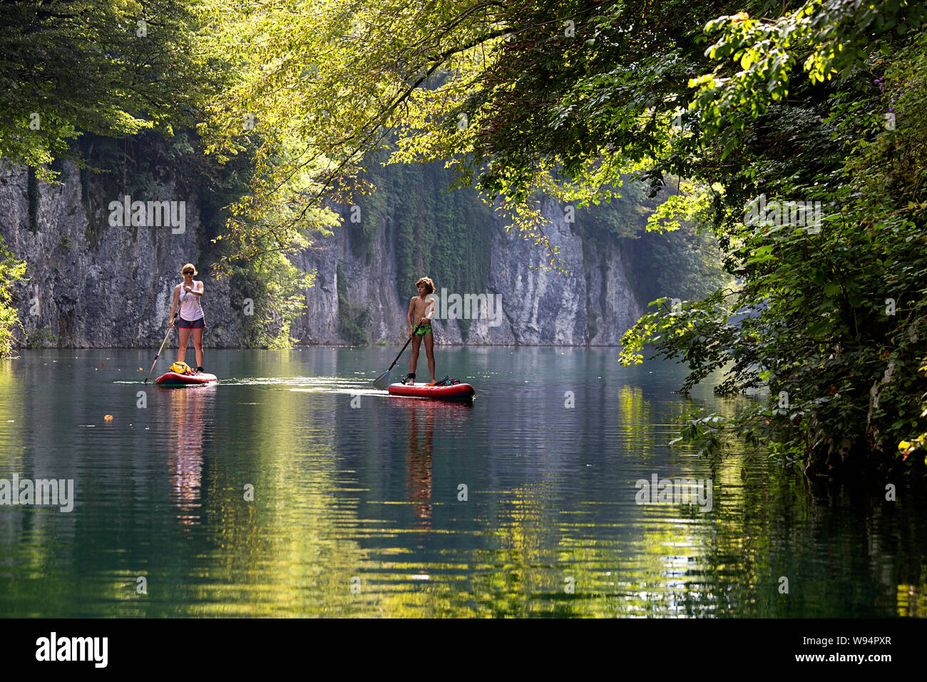 Mother and son having fun on stand up paddle on the beautiful Idrijca ...