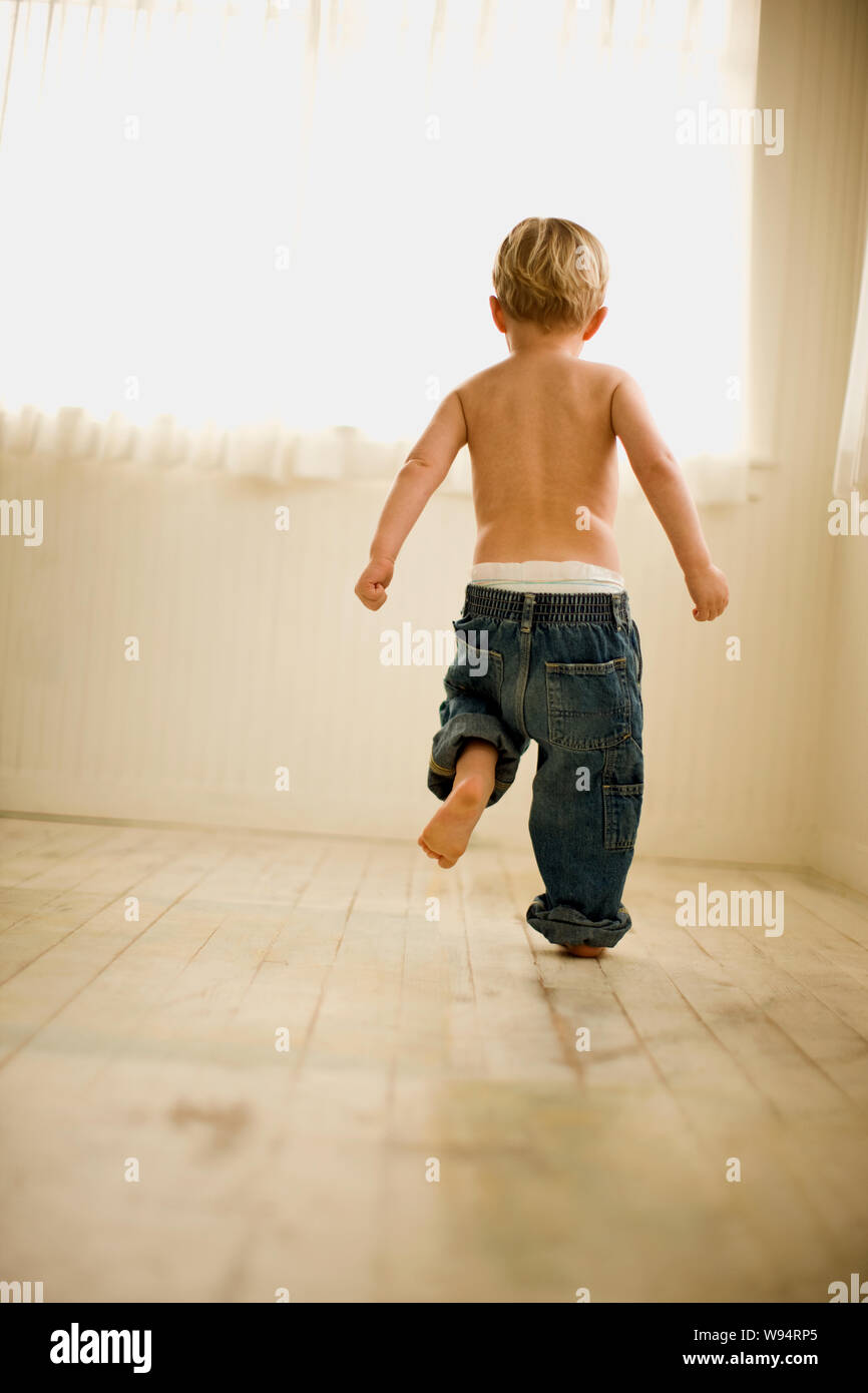 Young boy skipping in an empty room Stock Photo - Alamy