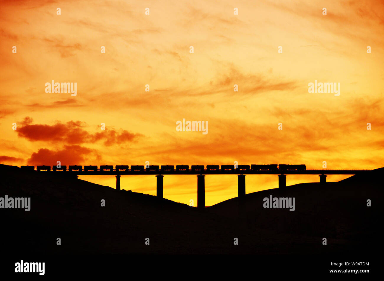 A freight train with liquid cargo passes across a bridge in Wusite ...