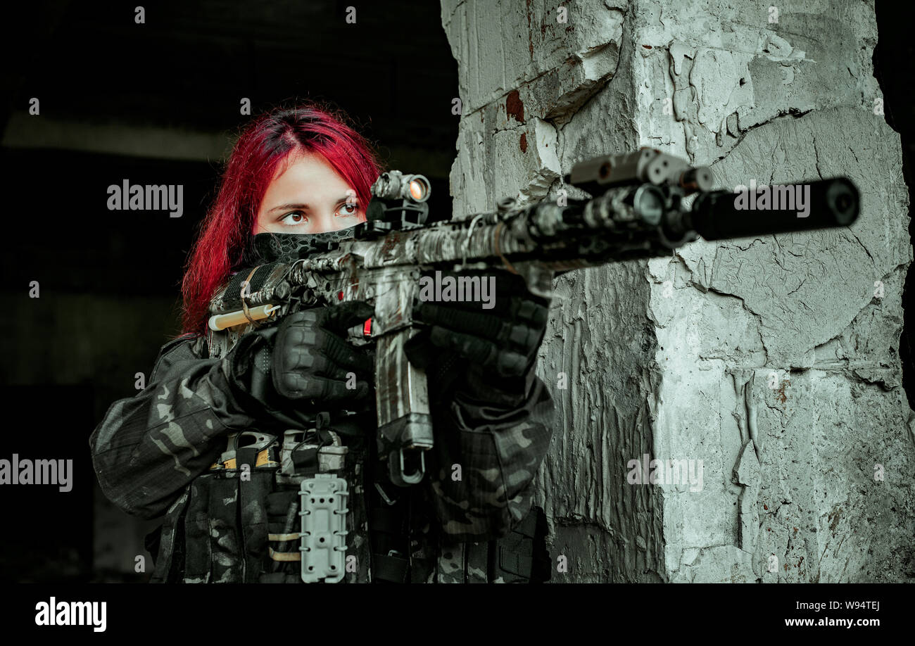 Red-hair woman in military uniform with machine gun inside ruine Stock ...
