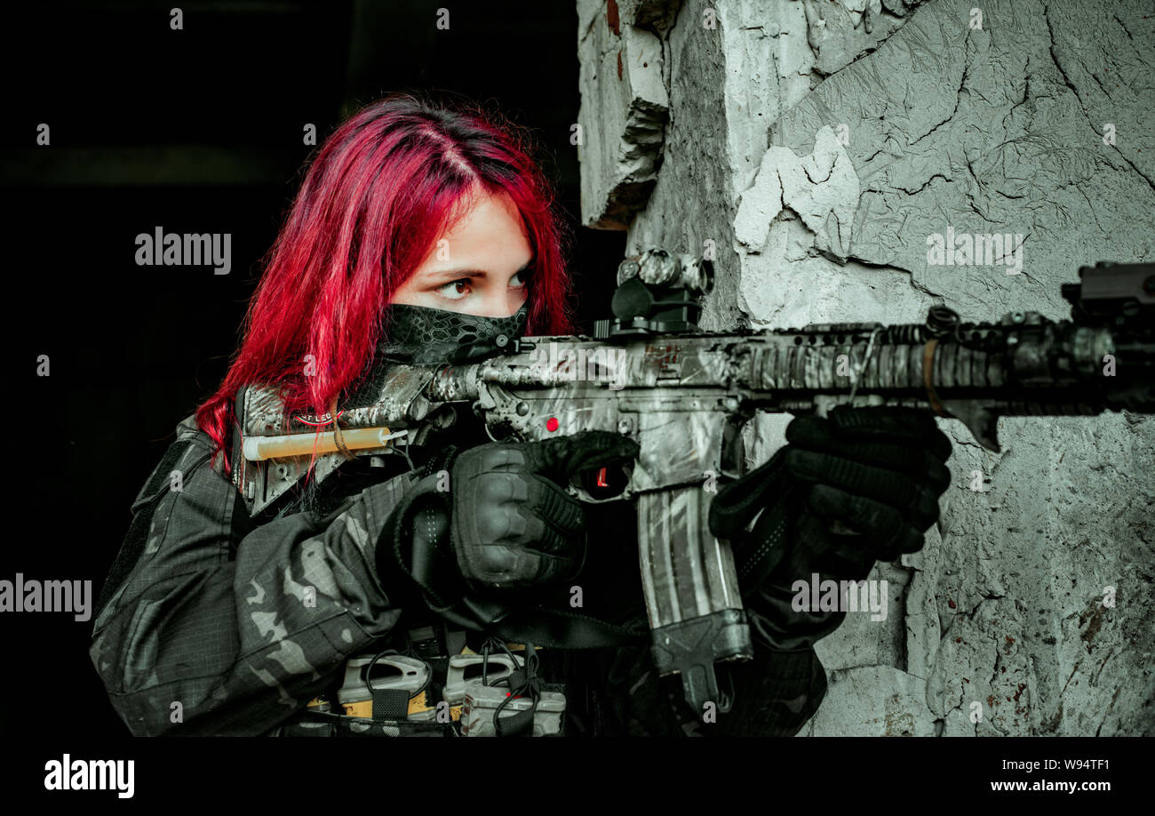 Red-hair woman in military uniform with machine gun inside ruine Stock ...