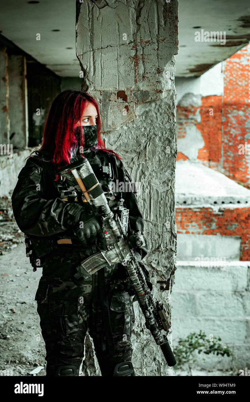Red-hair woman in military uniform with machine gun inside ruine Stock ...