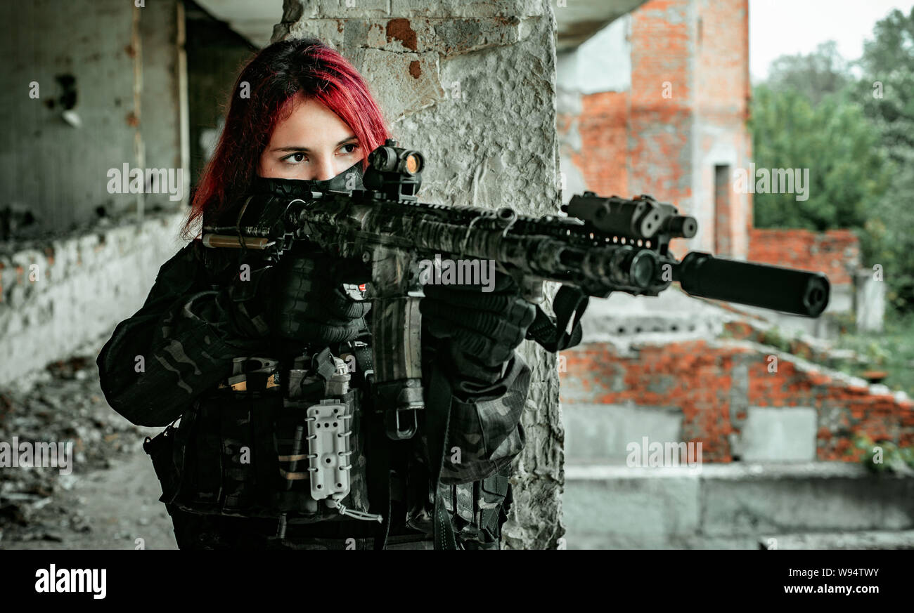 Red-hair woman in military uniform with machine gun inside ruine Stock ...
