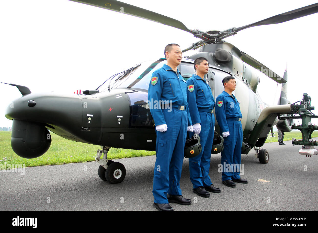 Crew members pose in front of a Z-9WZ attack helicopter during a ...