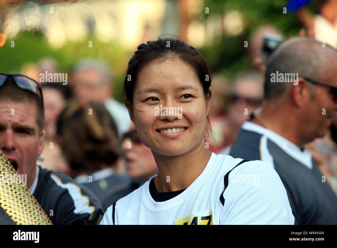 Chinese tennis player Li Na holds the Olympic torch to exchange the ...