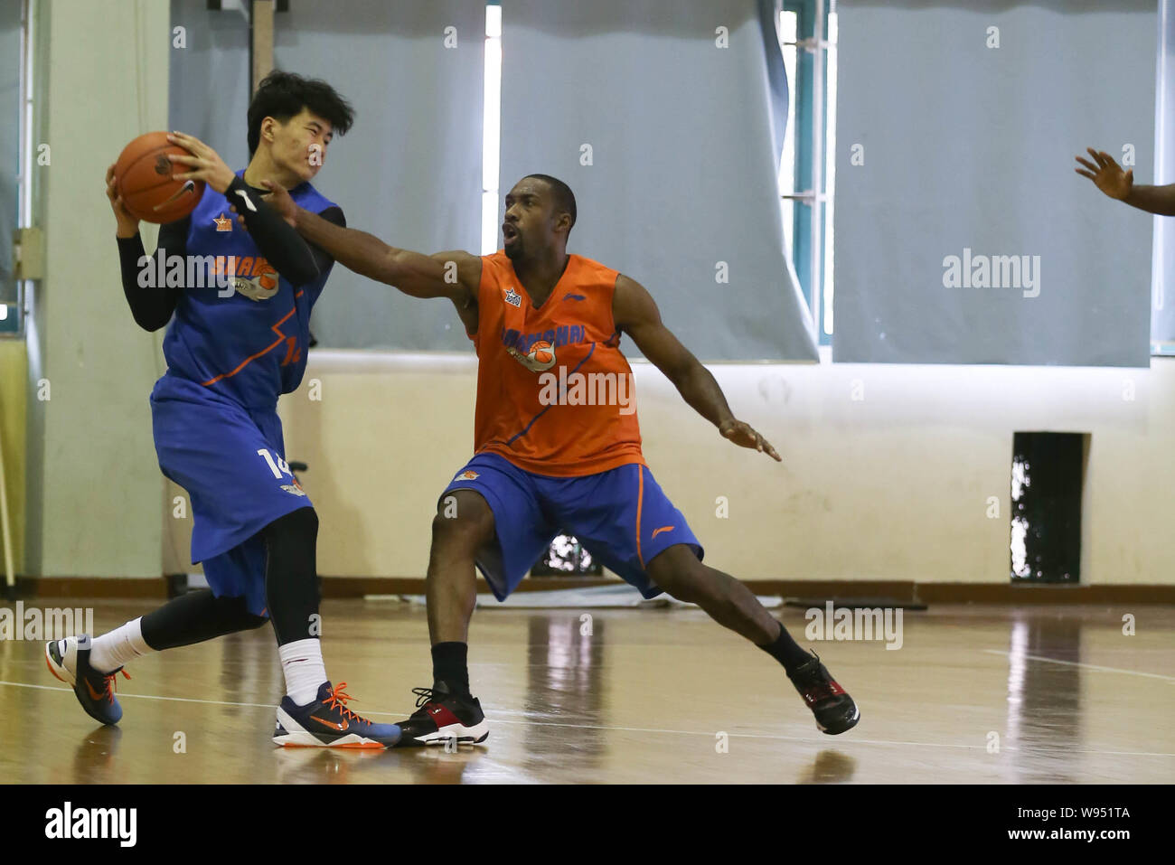 Gilbert Arenas of the Shanghai Sharks, right, challenges a teammate ...