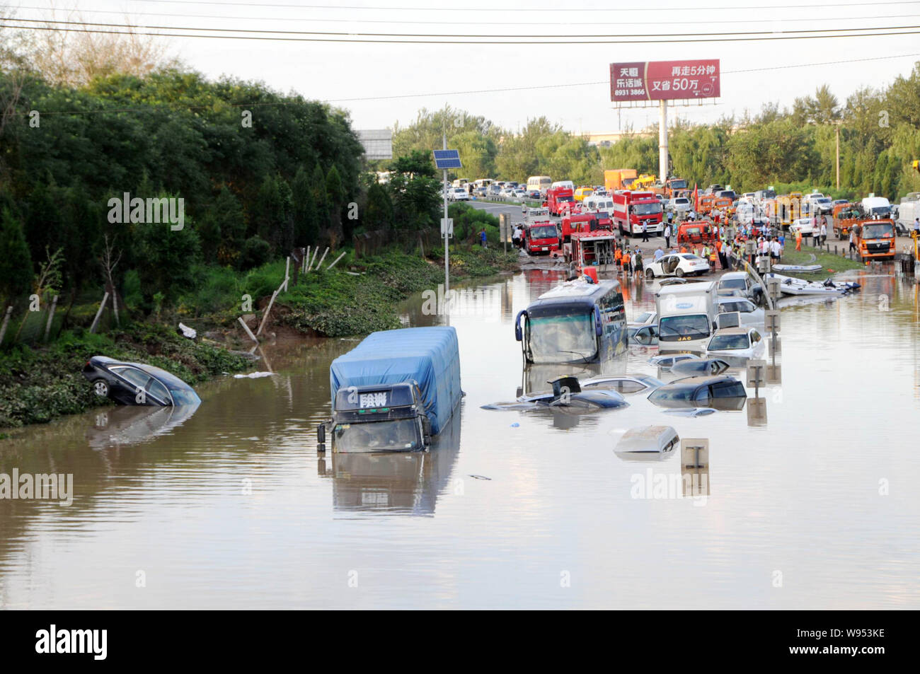 Trucks, cars and buses are submerged by floods caused by heavy rain on ...