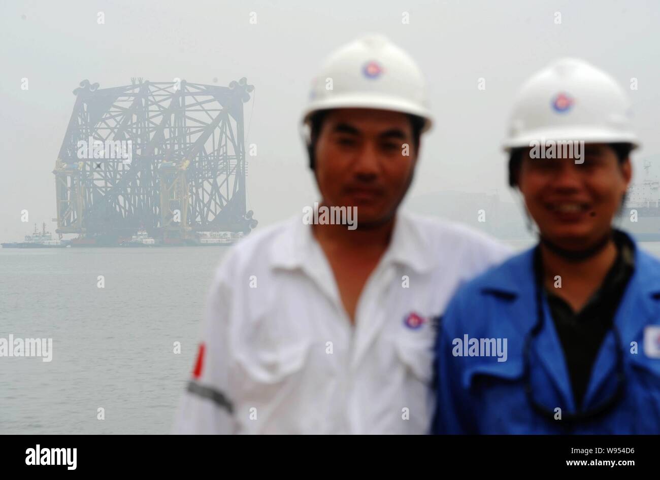 Chinese staff pose by the Liwan 3-1 jacket constructed by CNOOC before ...