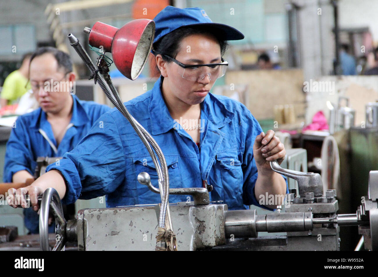 Chinese workers manufacture steel products at a factory in Qiqihar city ...